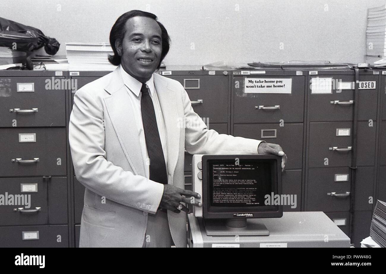 A photo of a man standing near a desk; behind file cabinets Stock Photo ...