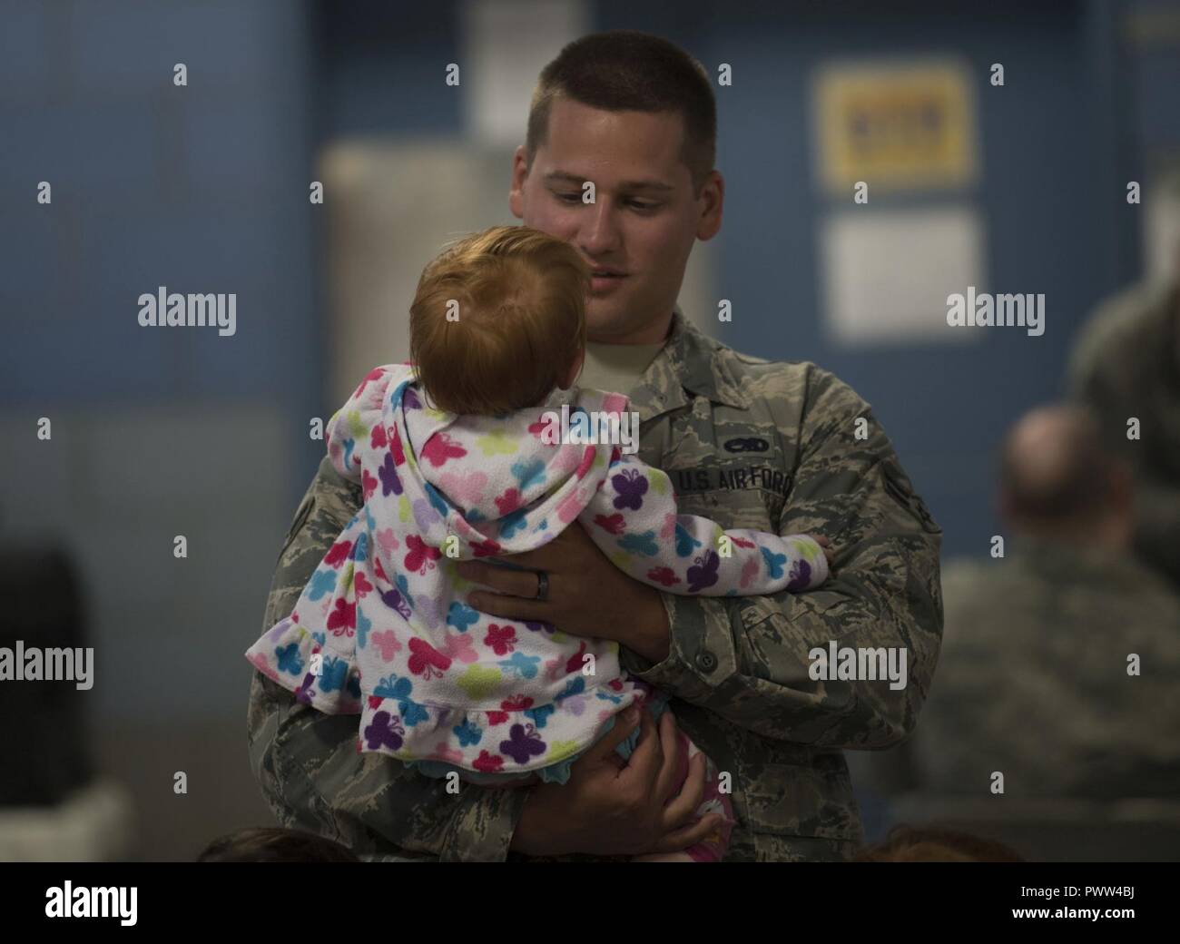 Airman 1st Class Cody Lusk holds Elaina Mullens, the child of Senior ...
