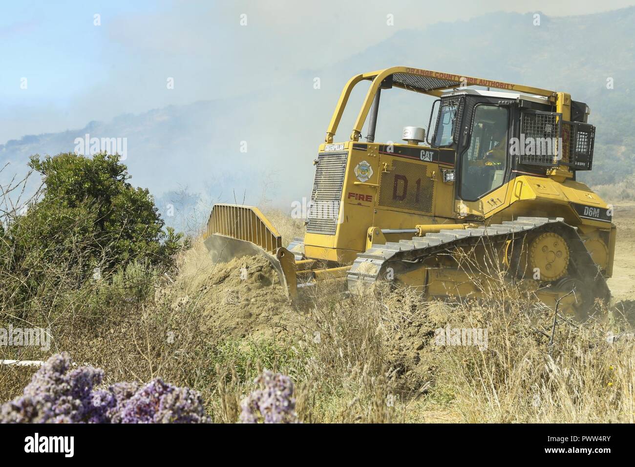 The Orange County Fire Department uses a bulldozer to create a fire ...