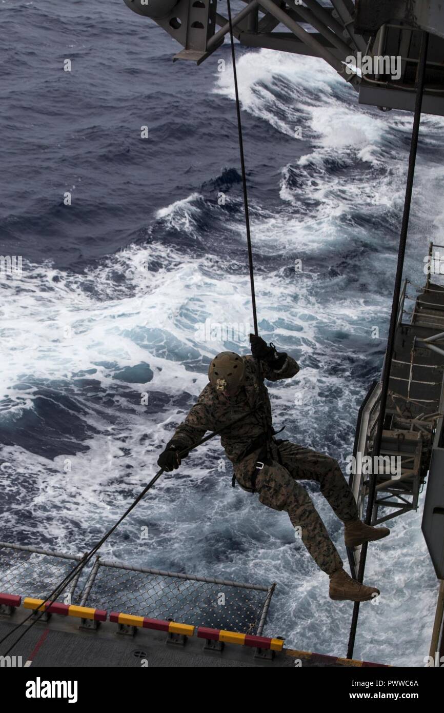 A Marine with the 31st Marine Expeditionary Unit rappels from the exit ramp of an MV-22B Osprey ...