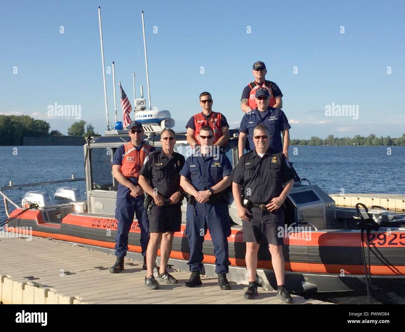 The Coast Guard and partner law enforcement agency personnel stand for ...