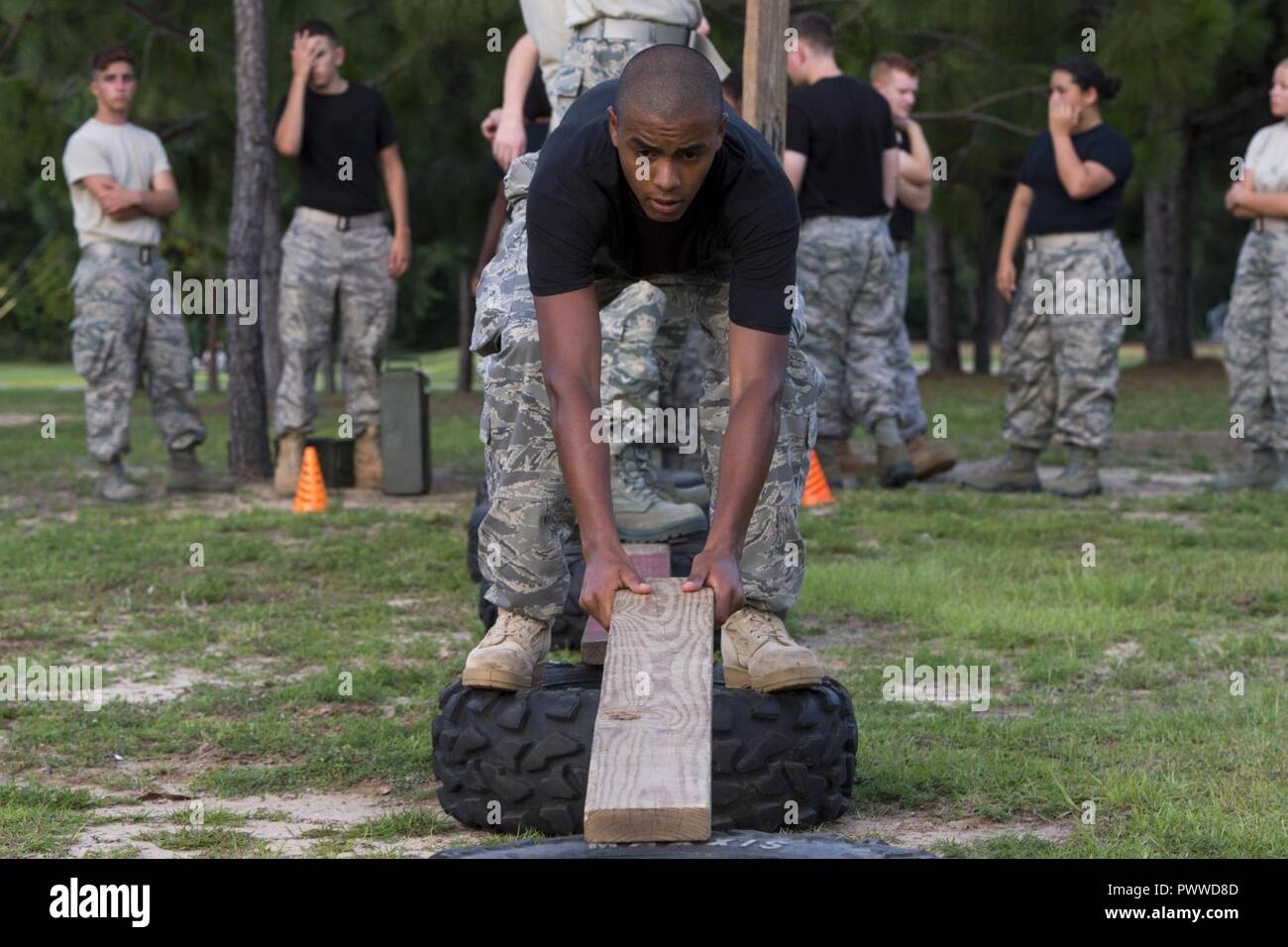 A Junior ROTC cadet lays a plank down to form a makeshift bridge ...