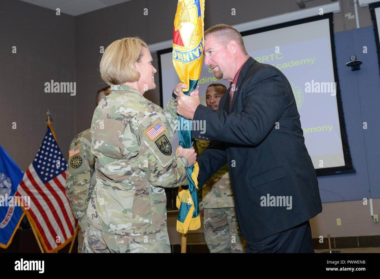 Outgoing RTA Commandant Mr. Jonathan Scholl, hands the battalion flag ...