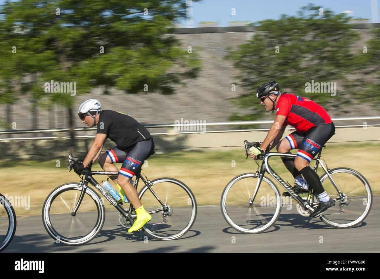 U.S. Marine Corps Master Sgt. Howard Tait cycles behind a member of ...