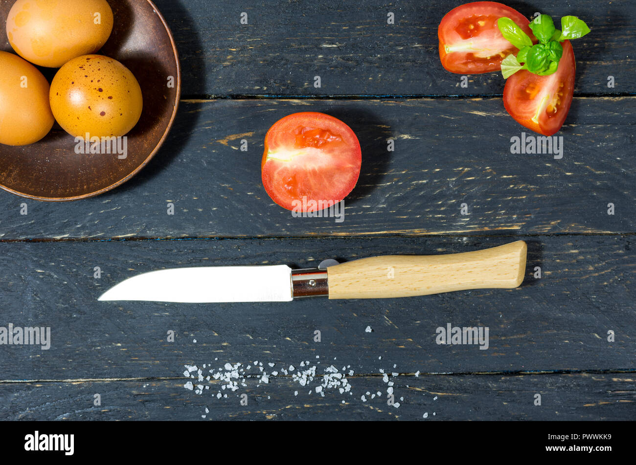 Slicing tomatoes with a pocket knife. Flat lay. Dark background Stock ...