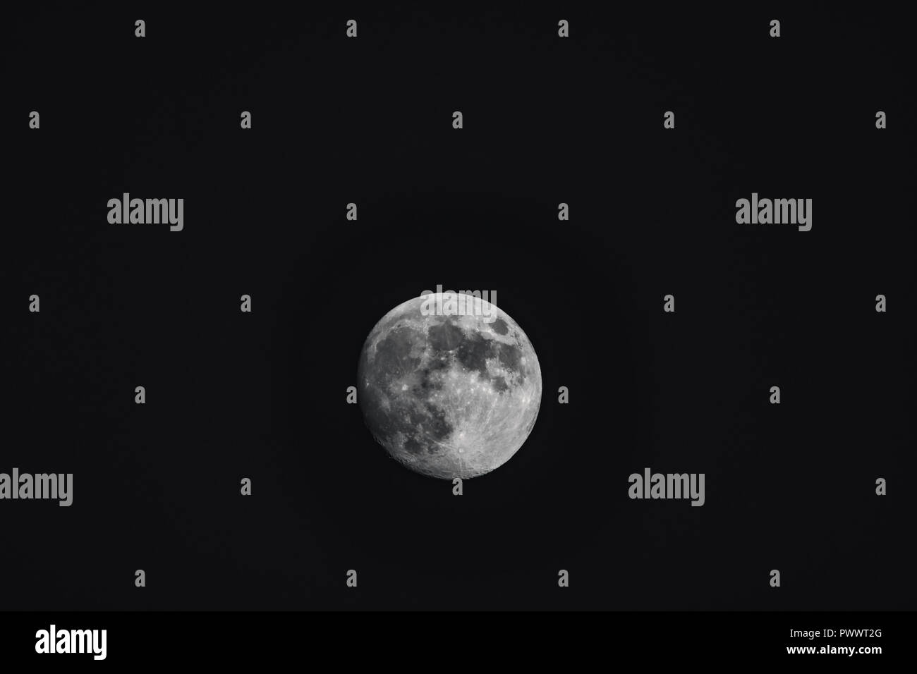 Almost full moon against black sky background Stock Photo - Alamy