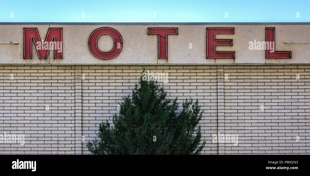 Motel sign with lighting tubes on a brick building Stock Photo - Alamy