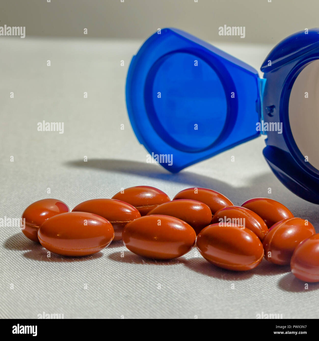 Pills and open bottle on fabric texture background Stock Photo - Alamy