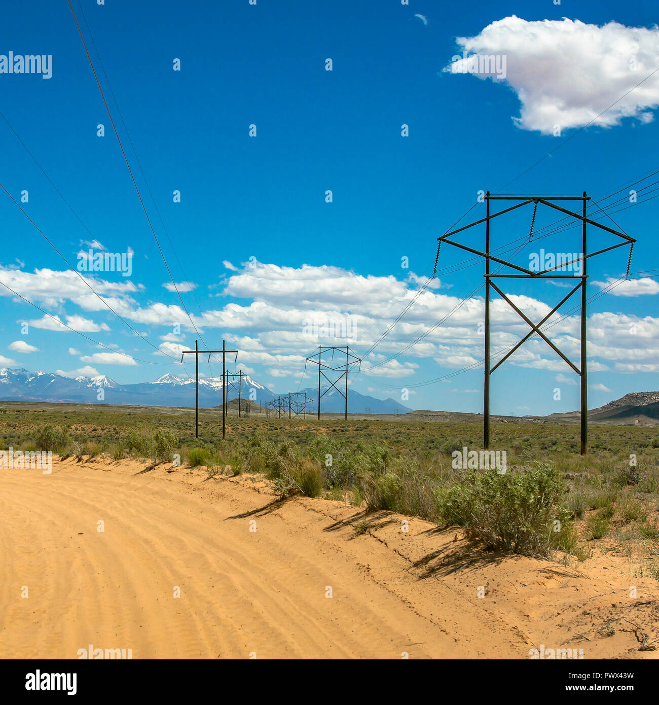 Electricity pylon in green field with blue sky with white hi-res stock ...