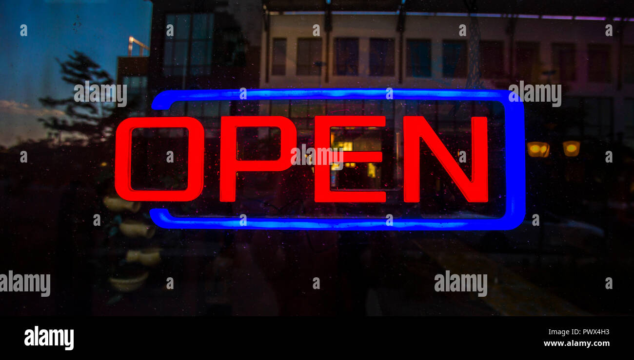 Red and blue open sign on a reflecive glass door Stock Photo - Alamy
