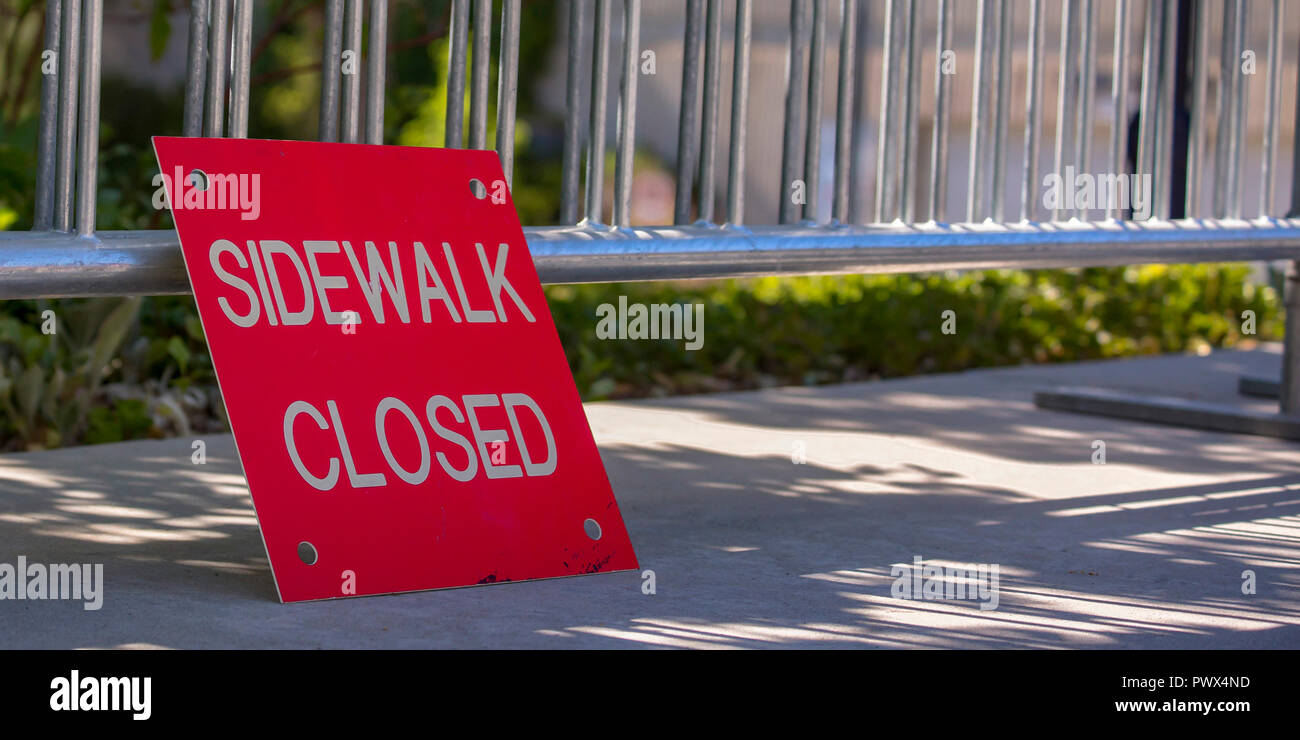 Red sidewalk closed sign on a sunny pavement Stock Photo - Alamy