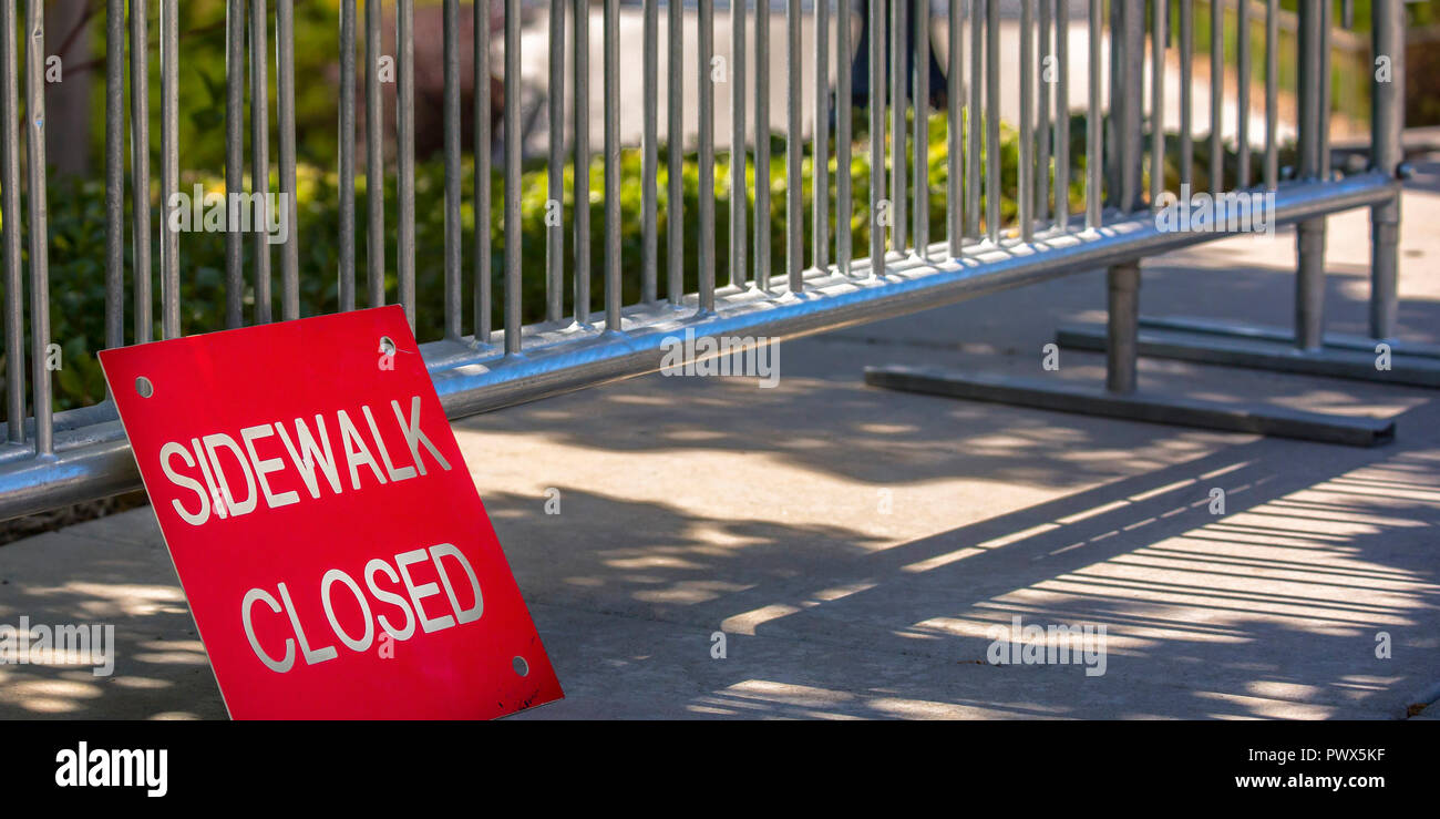 Sidewalk closed sign on a pavement with railing Stock Photo - Alamy