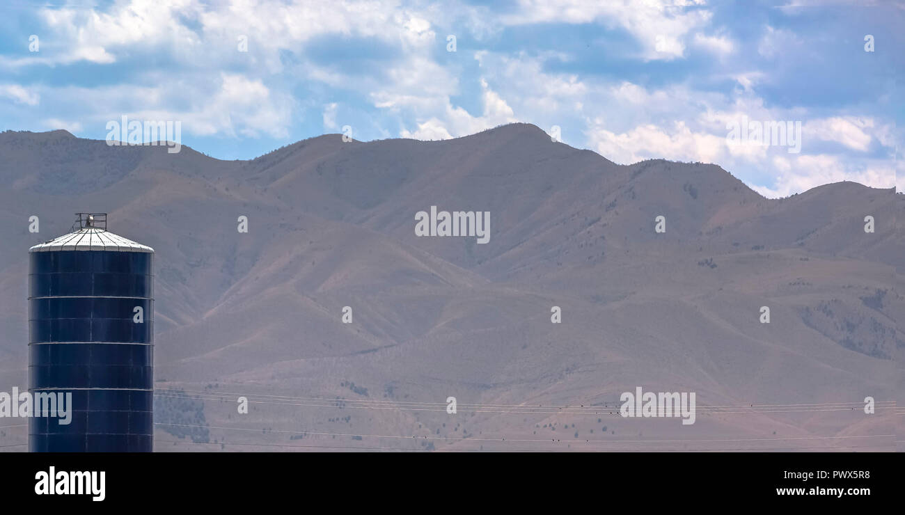 Silo and mountain beneath sky with clouds in Utah Stock Photo - Alamy