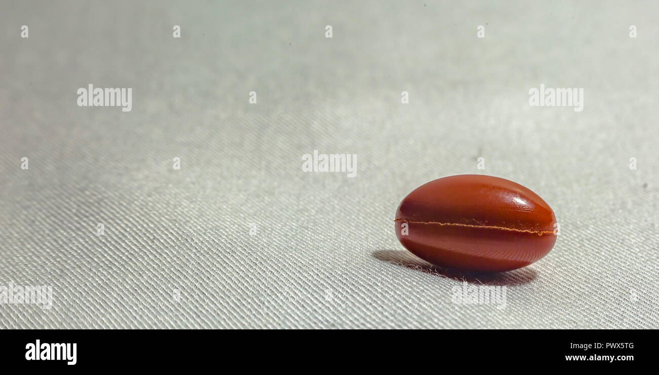 Single pill on a white fiber texture background Stock Photo - Alamy