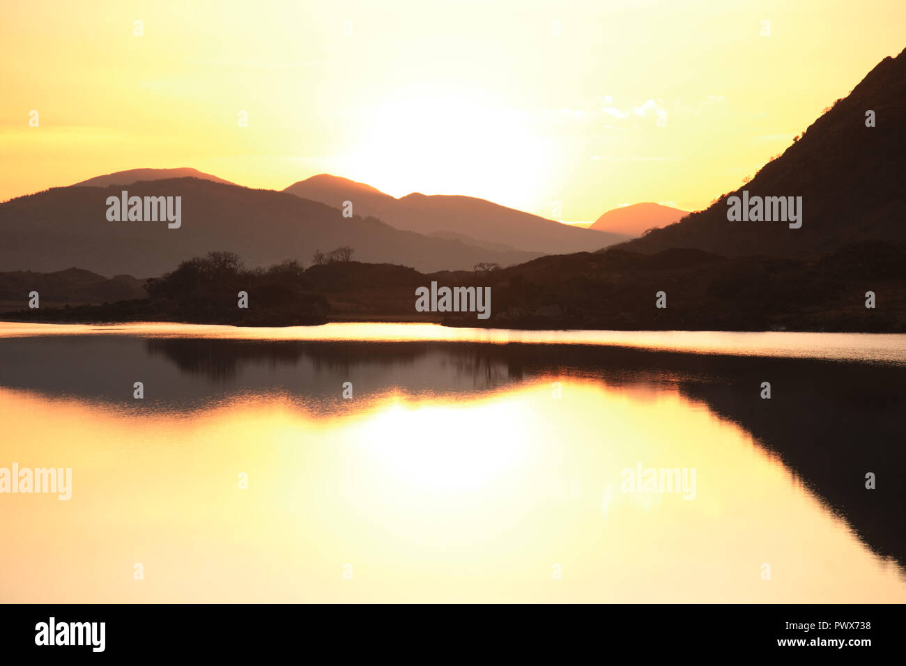 evening sky reflecting on calm lake waters, killarney national park ...