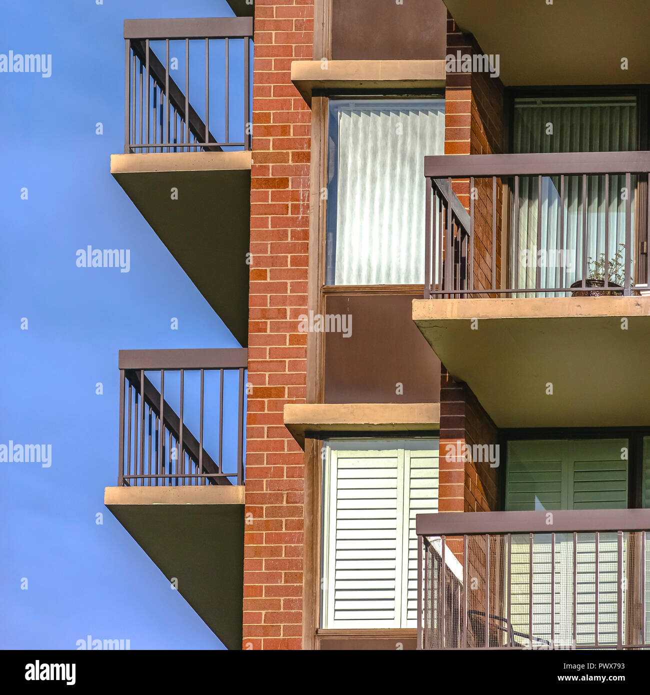 Sunlit balconies of a red brick building Stock Photo - Alamy