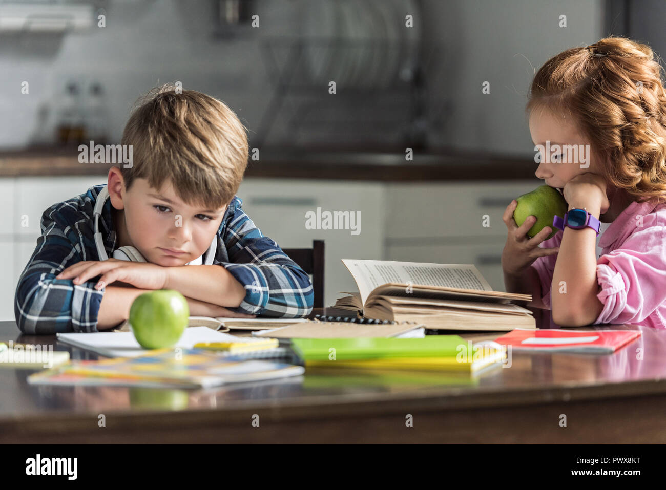 little brother and sister with green apples doing homework Stock Photo ...