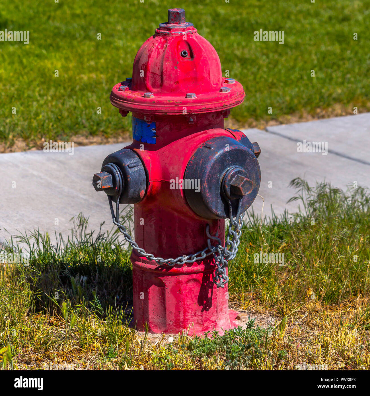 Weathered red fire hydrant on a grassy ground Stock Photo - Alamy