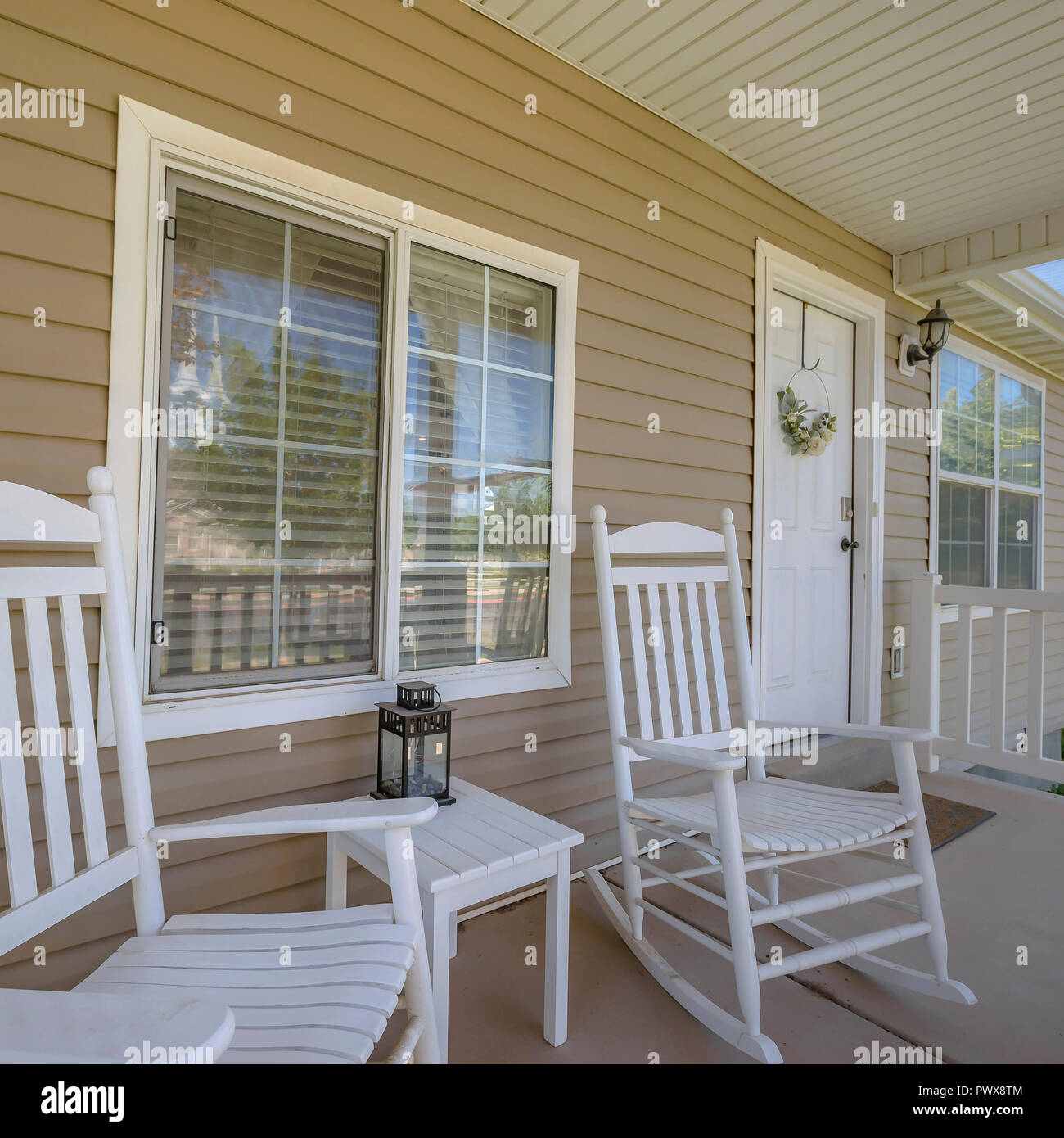 White door and porch with rocking chairs and table Stock Photo - Alamy