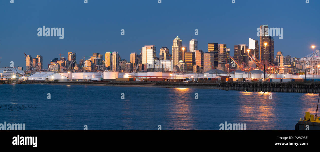 The Seattle Washington waterfront glows at dusk showing tanks and ...