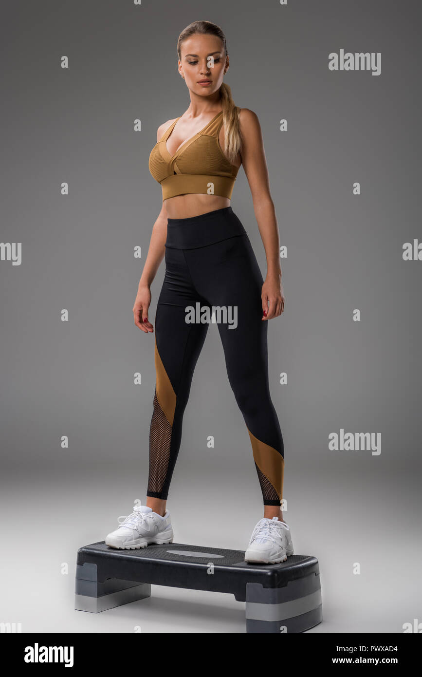 fit young woman doing step aerobics on grey Stock Photo - Alamy