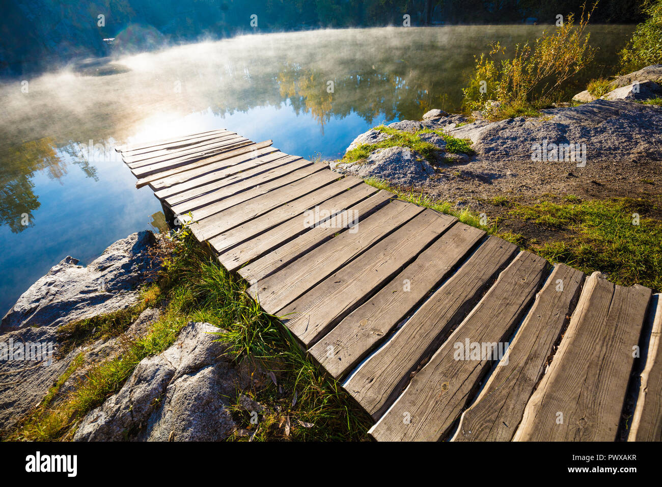 Wooden deck on the rocky lakeshore in the early misty morning Stock ...