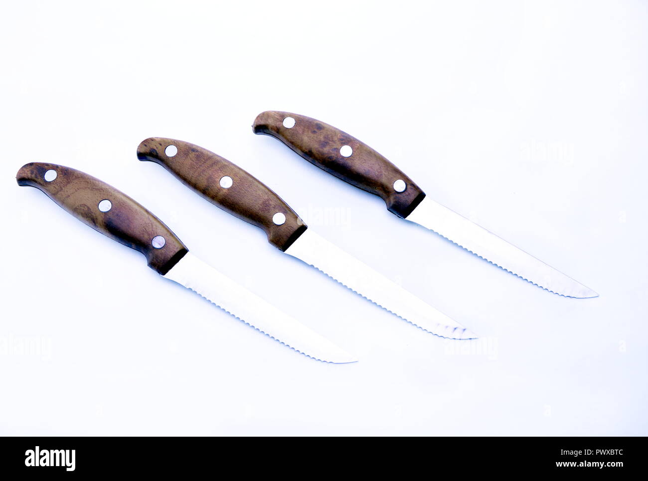 set of three knives on a white background Stock Photo - Alamy