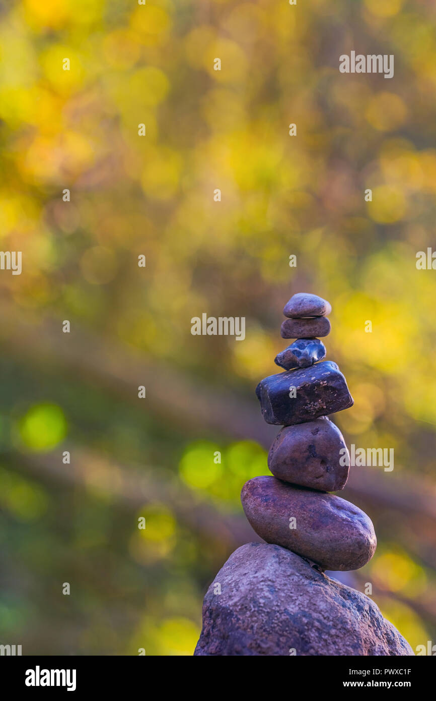 Stacked stone pyramid in front of green blurry background with bokeh ...