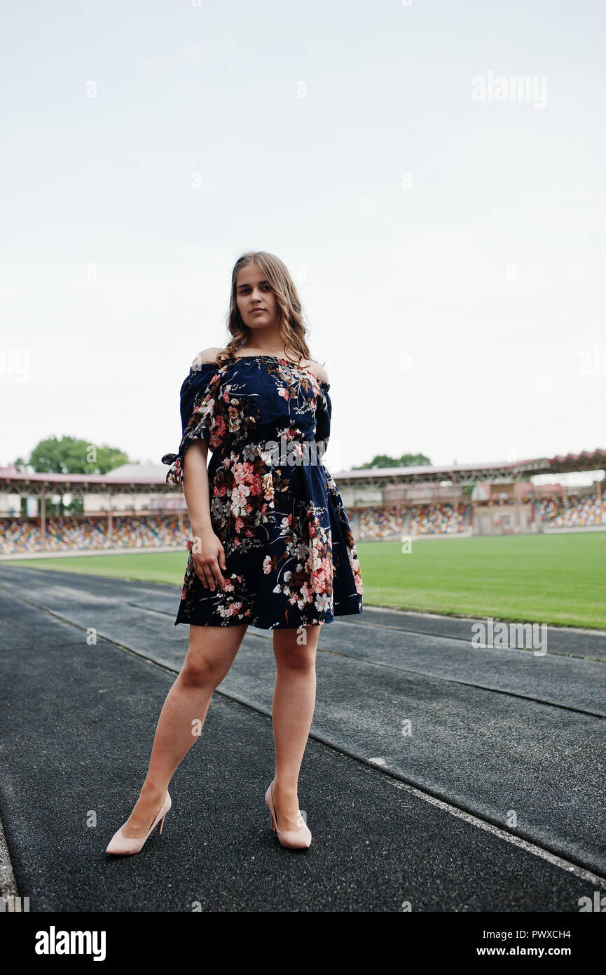 Portrait of a fabulous girl in dress and high heels on the track at the ...