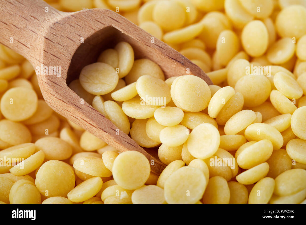 Organic cacao butter buttons (wafers) in wooden scoop Stock Photo - Alamy