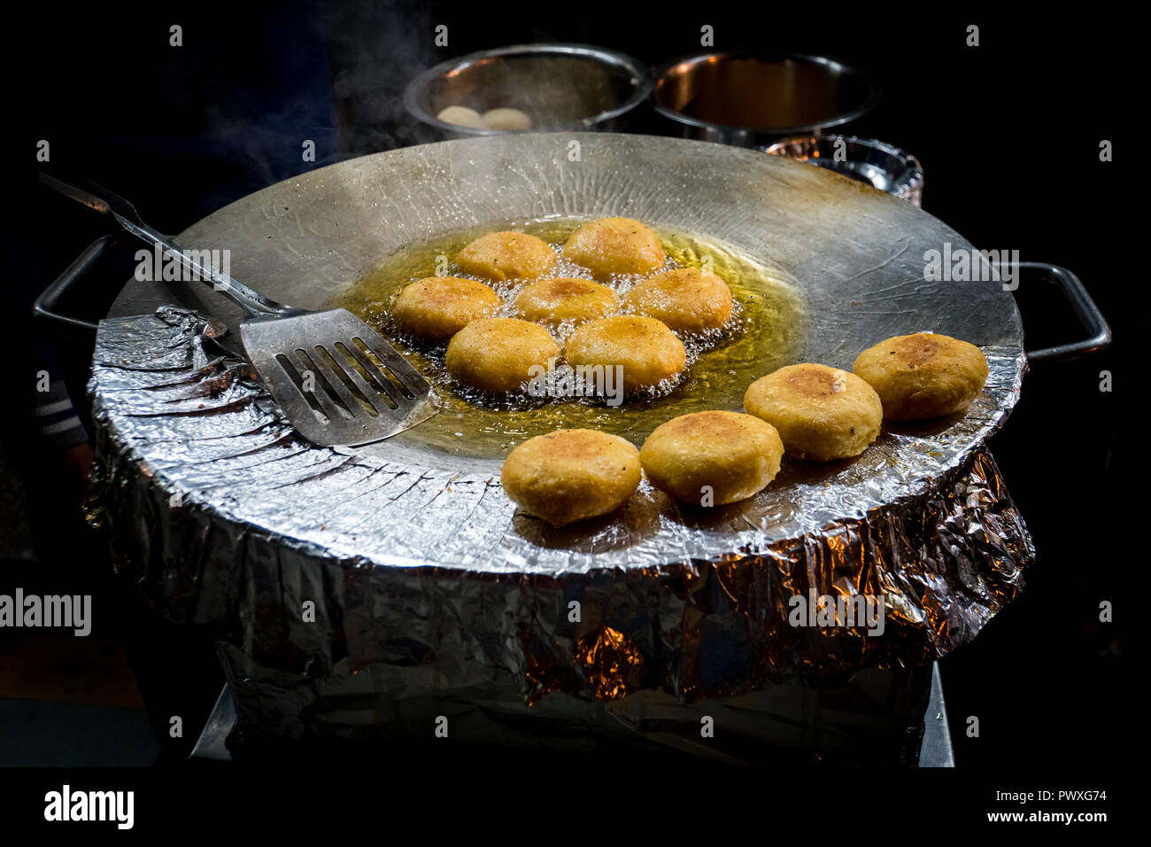 Potato pancakes fried in boiling oil. Street food in India. Indian ...