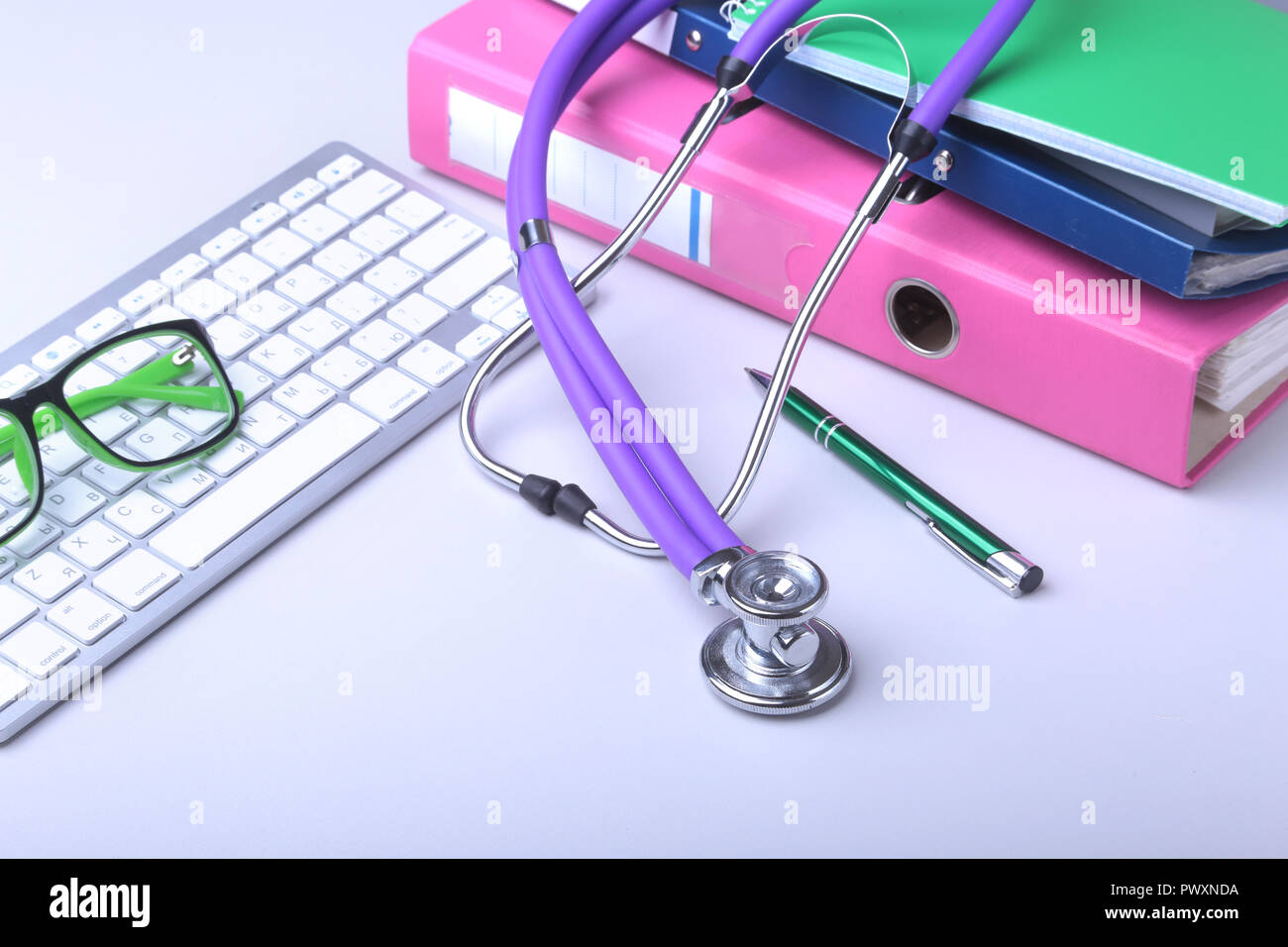 Medical record concept with stethoscope over pile of folders. Keyboard ...