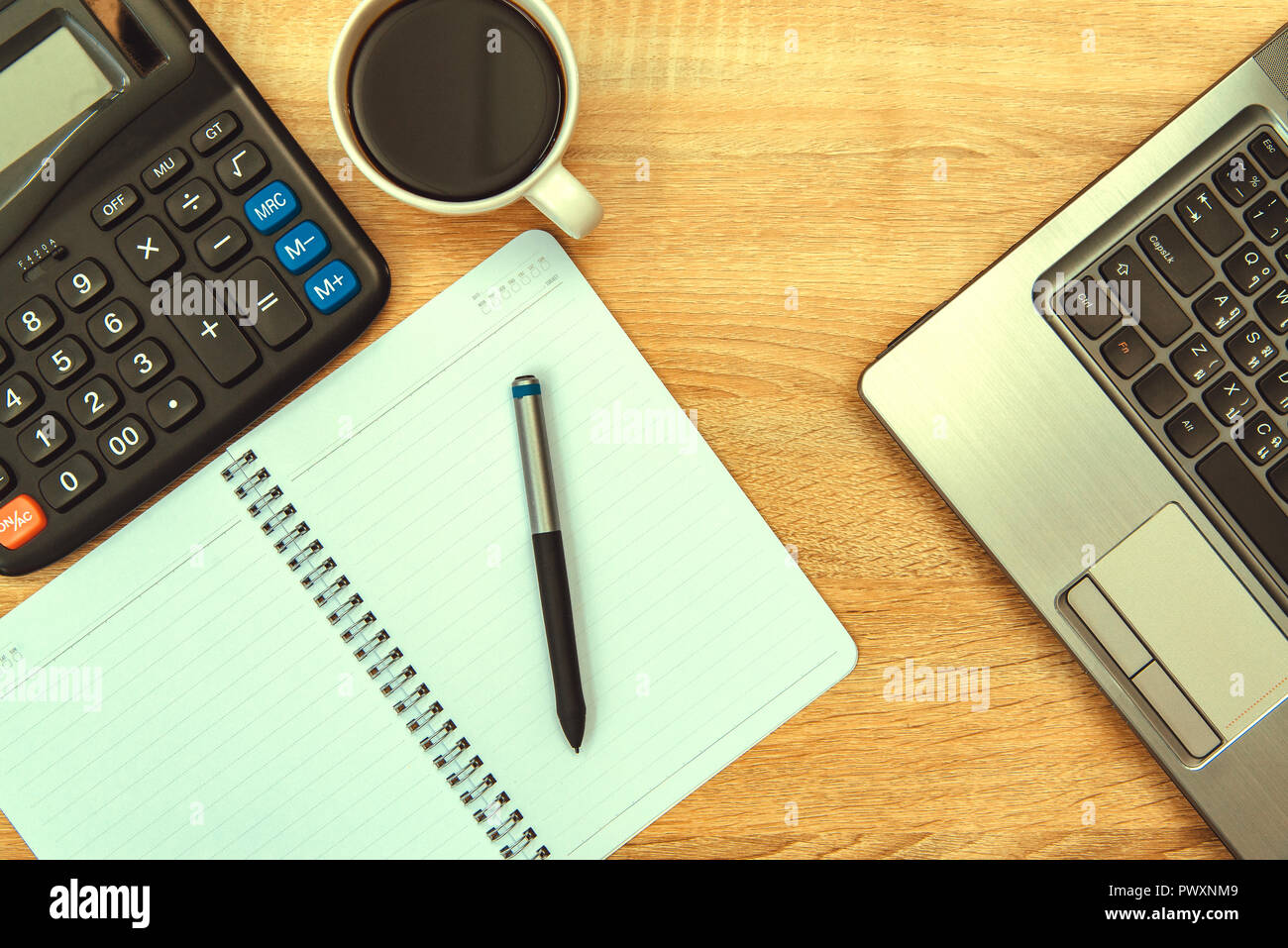 Laptop computer or notebook, calculator and cup of coffee on working ...
