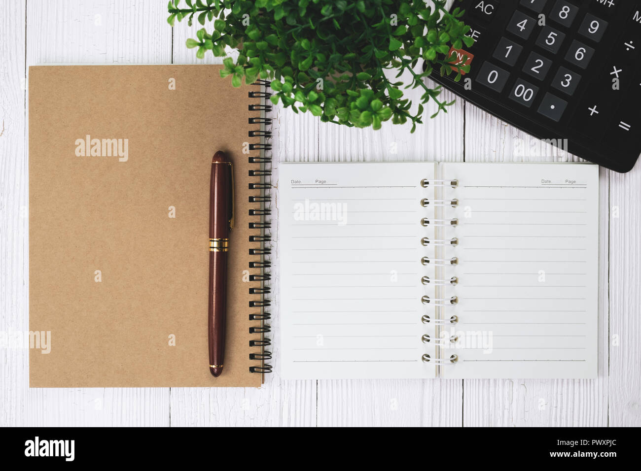 Fountain pen or ink pen with notebook paper and calculator on wooden ...