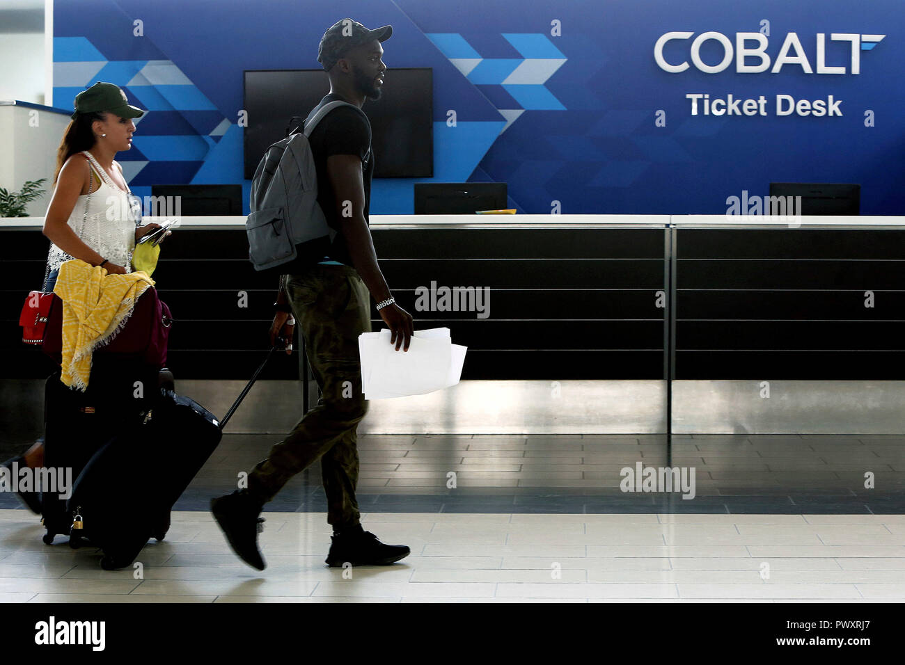 Passengers walk in front of Cobalt air ticket office at Larnaca ...
