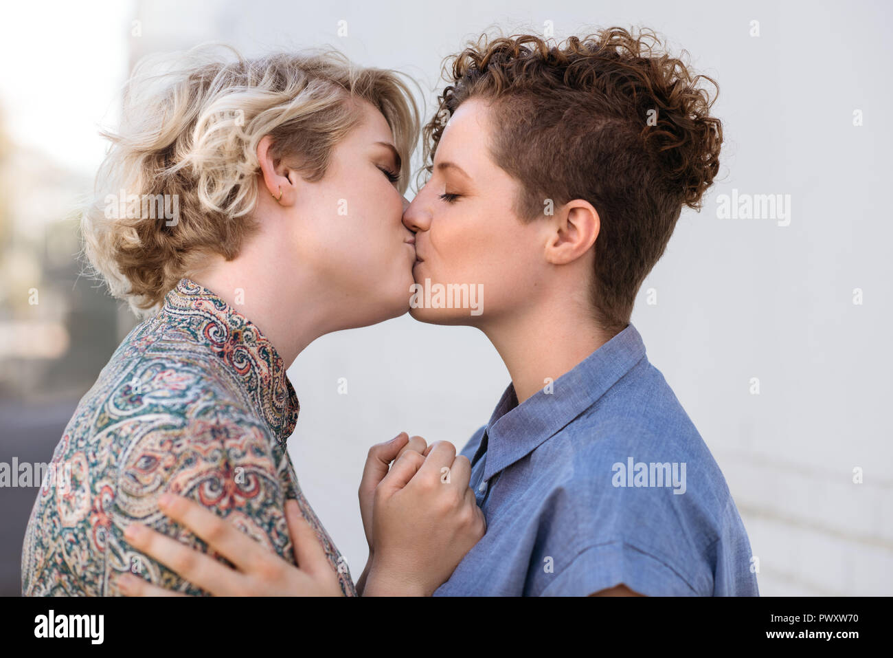 Affectionate Young Lesbian Couple Standing Outside Sharing A Kiss Stock Affectionate Young Lesbian Couple Standing Outside Sharing A Kiss Stock