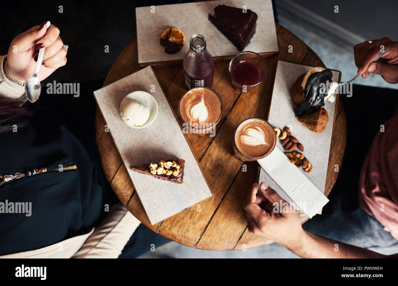 Friends enjoying desserts and coffee together in a cafe Stock Photo - Alamy