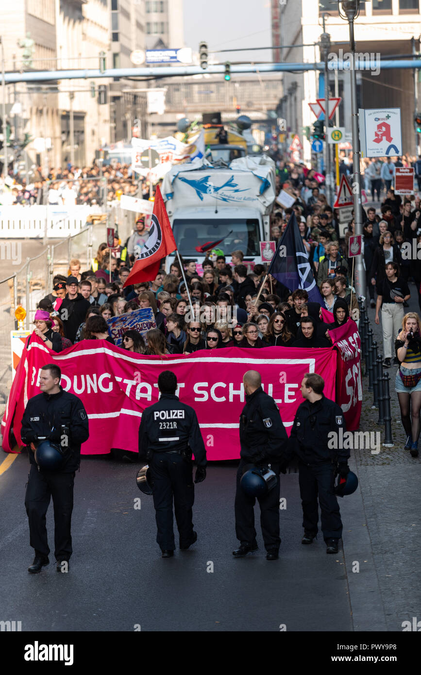 Police officers are seen a head of the students holding a banner and ...
