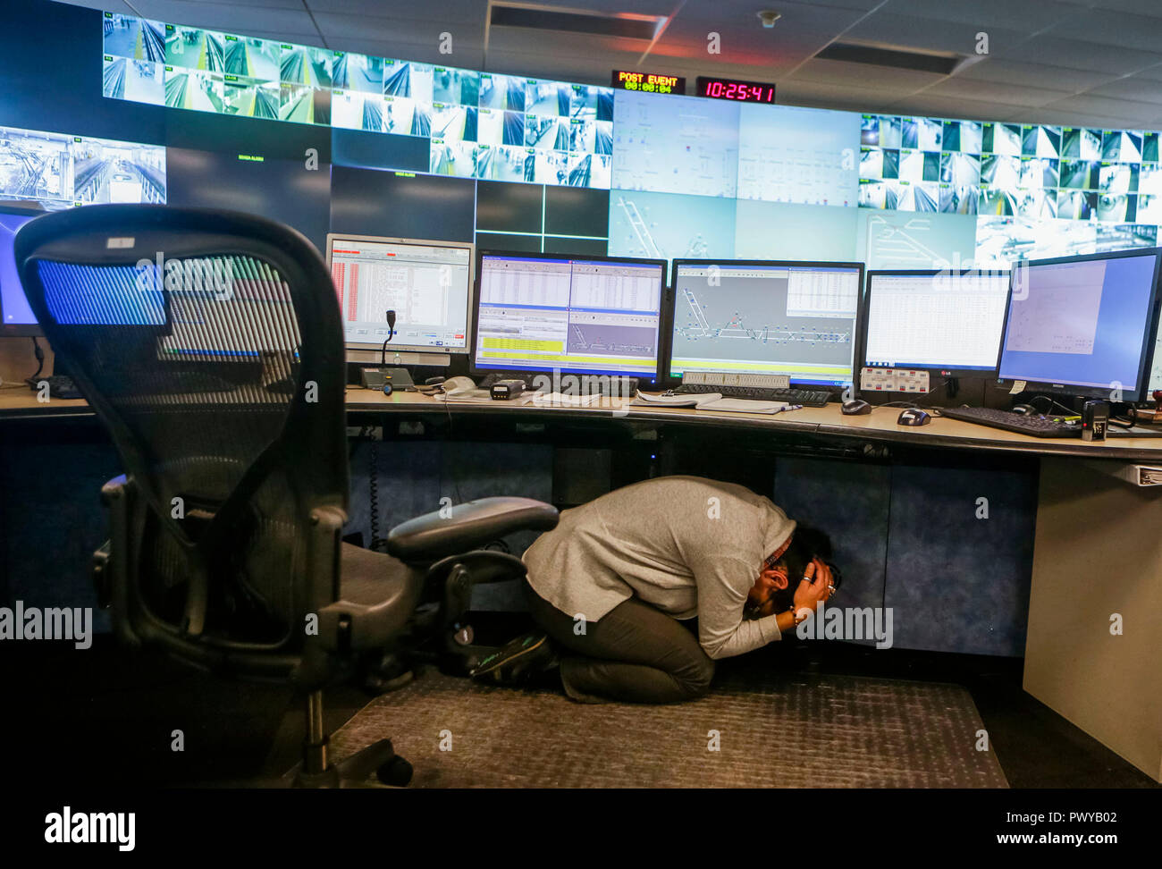 Vancouver, Canada. 18th Oct, 2018. A staff member takes cover under the ...