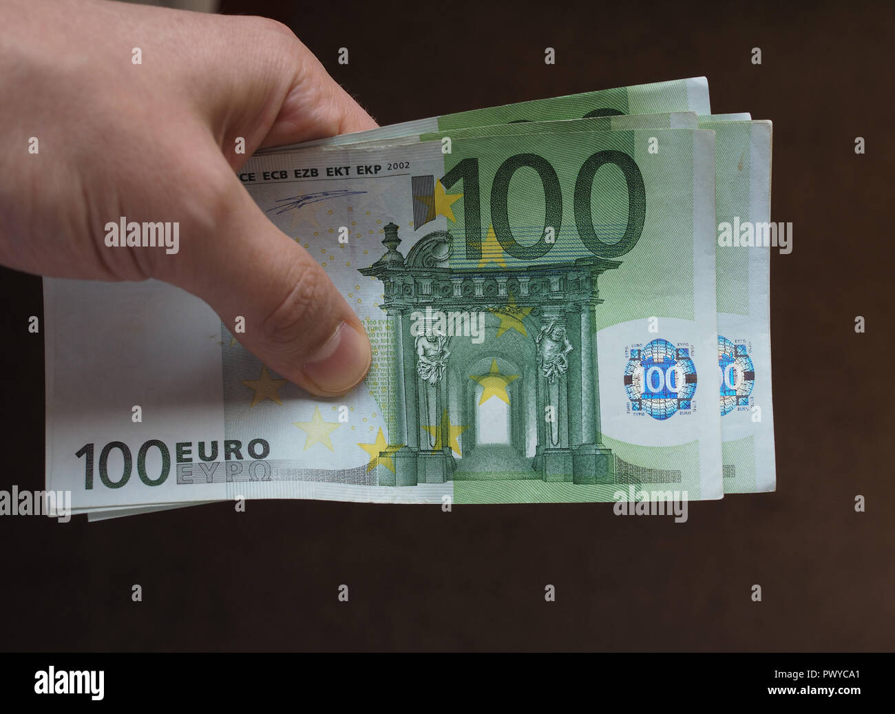 Hand holding and giving Euro banknotes money (EUR), currency of ...