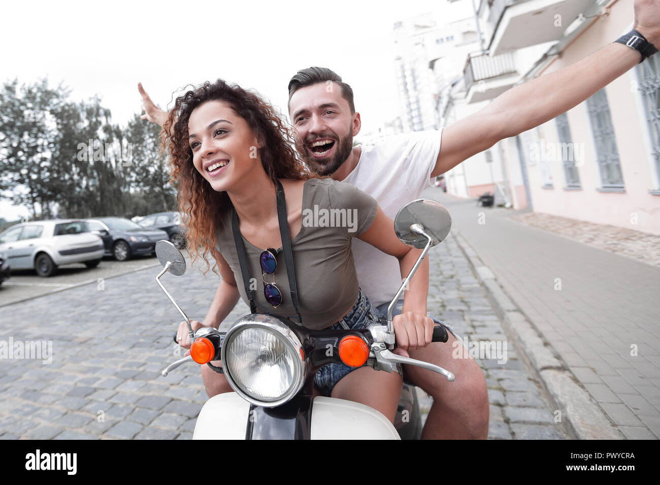 Couple riding motor scooter in old city street Stock Photo - Alamy