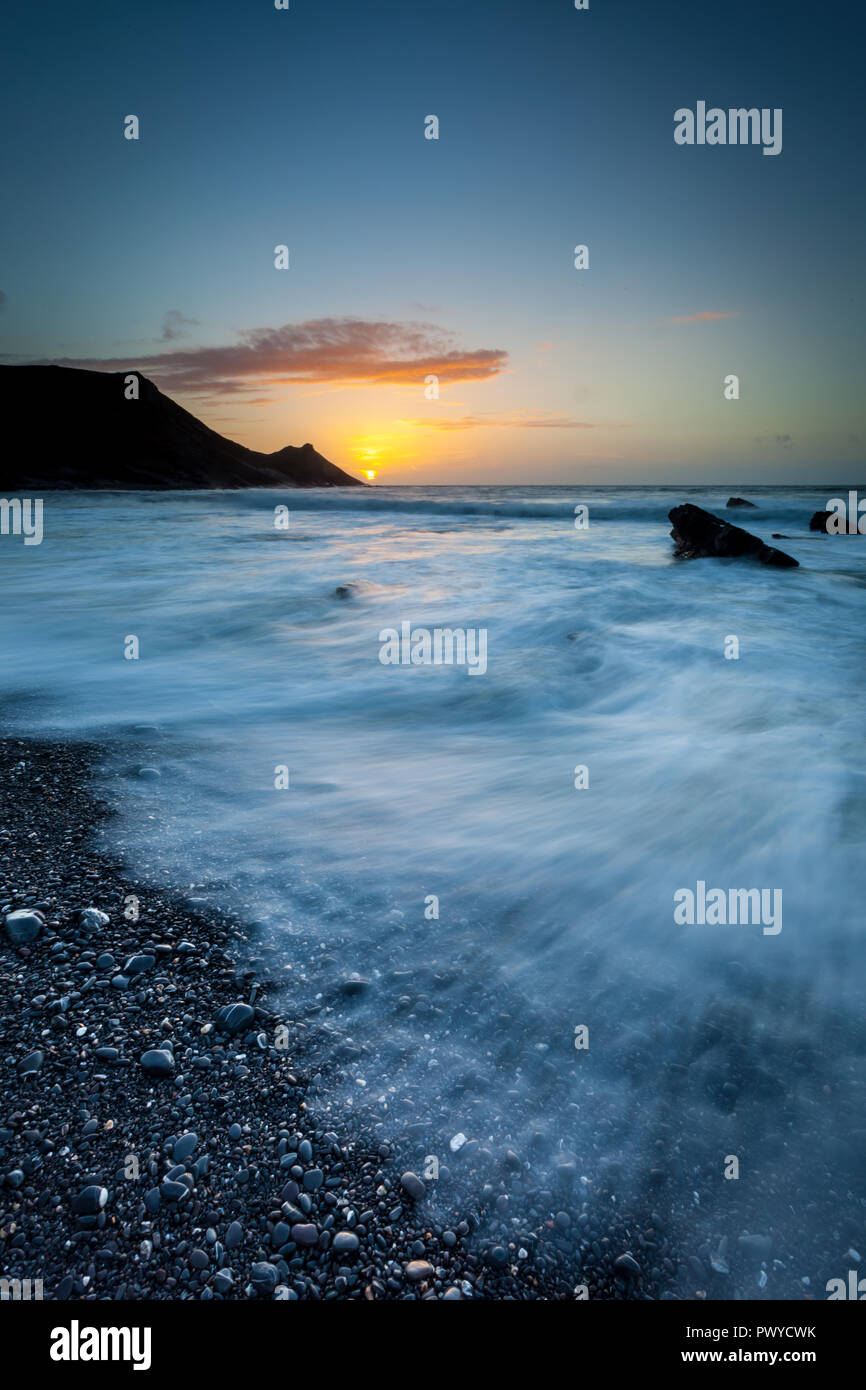 Waves crash on the pebbly shore at Millook Haven Stock Photo - Alamy