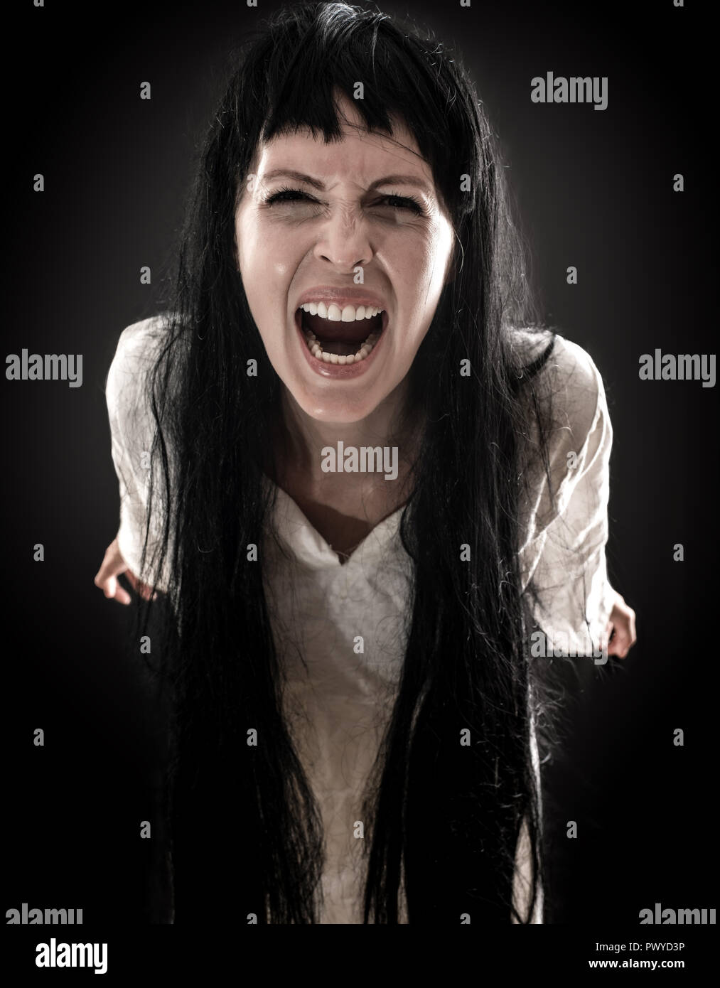 Halloween horror. Crazy bloody scary zombie woman looks into the camera ...