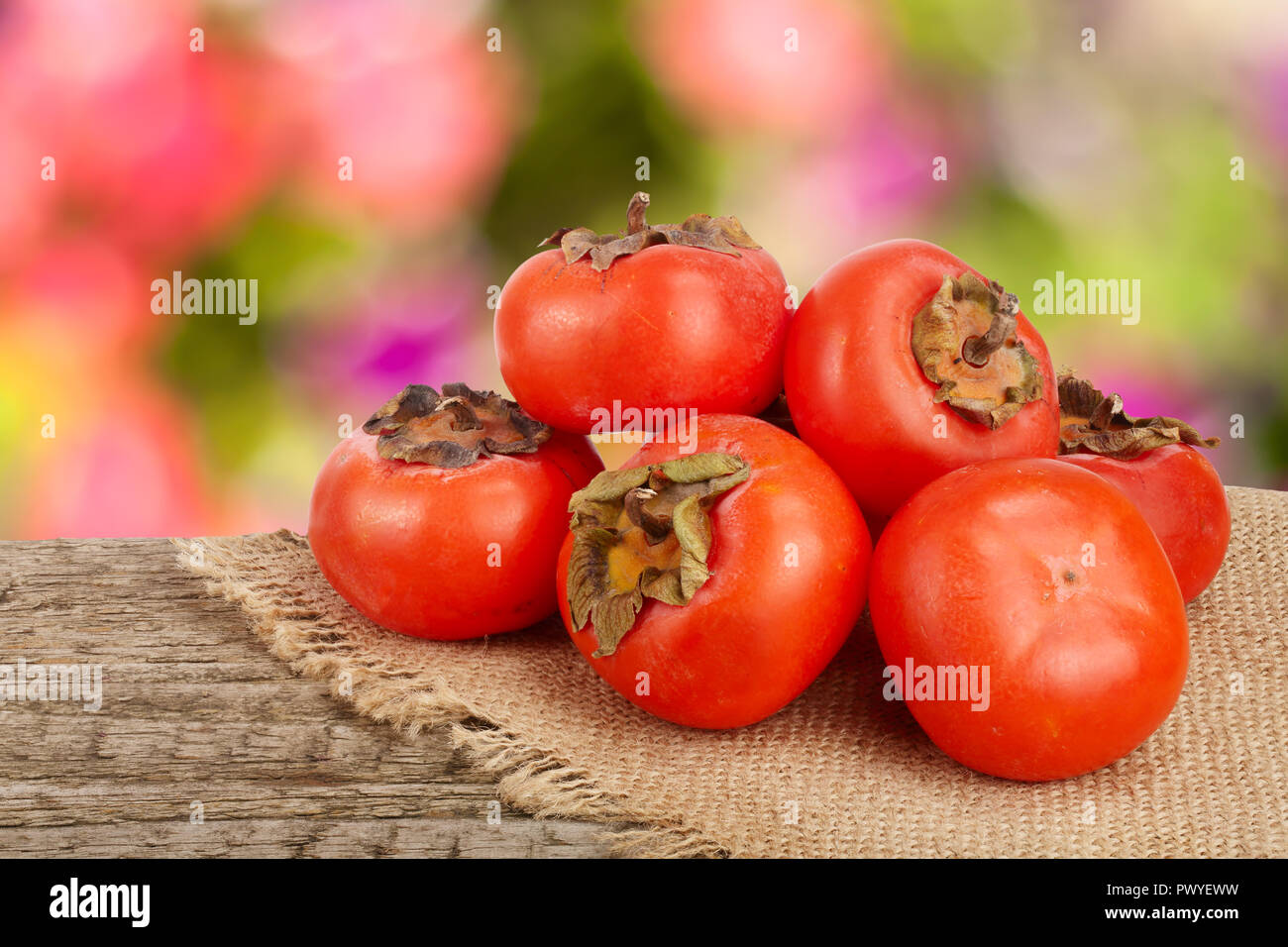 Persimmon fruit on wooden table with blurred garden background Stock ...