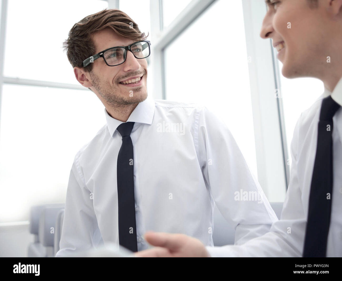 close up.two smiling employees at the Desk Stock Photo - Alamy