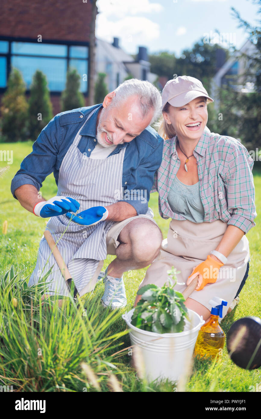 Happy loving couple taking care of their garden bed outside the house ...