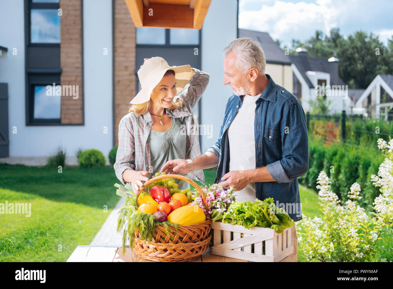 Caring loving husband helping his wife standing outside and cooking ...