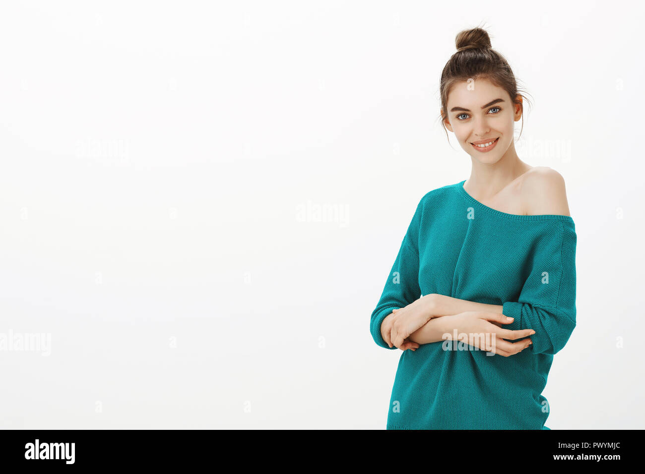 Studio shot of feminine sensual female in loose sweater, showing ...
