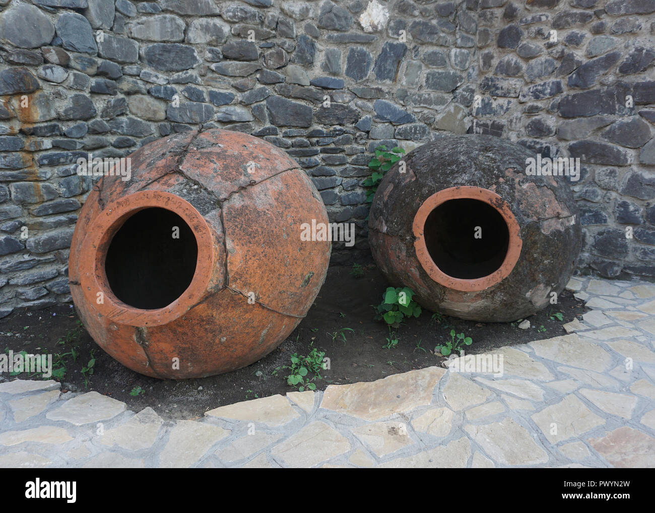 Two Empty Georgian Wine Jars in Front of a Stone Wall Stock Photo - Alamy