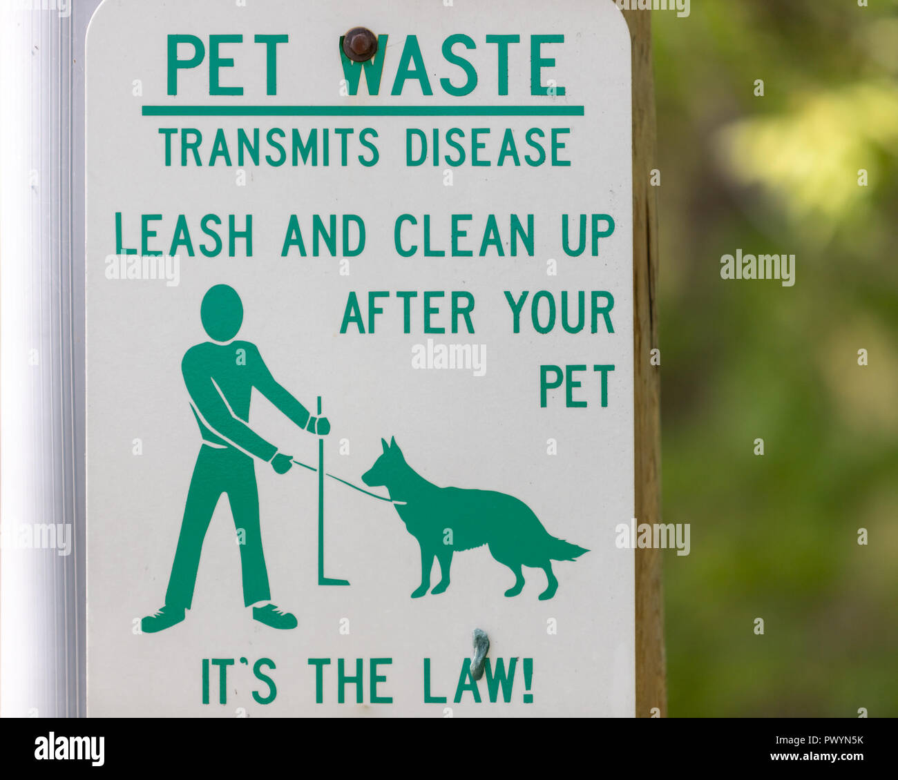 Park sign asking you to pick up your pets waste Stock Photo - Alamy